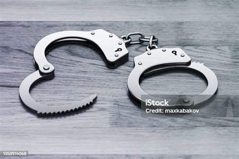 나무 배경에 경찰 금속 수갑 형사 사법 및 용의자 체포 개념 바닥에 강철 수갑 3d 렌더링 수갑에 대한 스톡 사진 및 기타 이미지 Istock