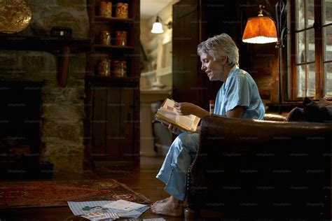 의자에 앉아 책을 읽고 있는 여자 사진 Unsplash의 성인 전용 이미지