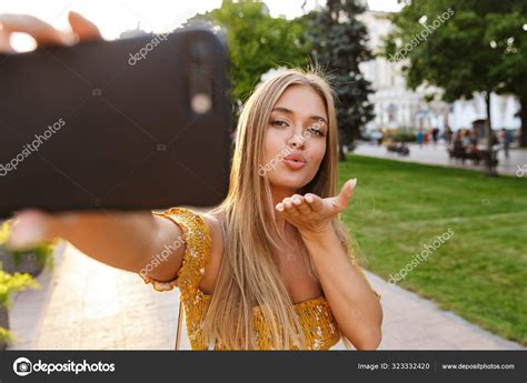 Красивая улыбающаяся молодая блондинка делает селфи стоковое фото ©vadymvdrobot 323332420