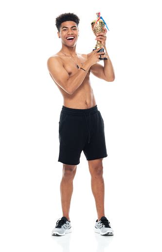 흰색 배경 앞에 서있는 아프리카 계 미국인 인종 젊은 남성은 반바지를 입고 트로피를 들고 18 19세에 대한 스톡 사진 및 기타 이미지 18 19세 1위