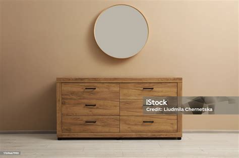 둥근 거울이 있는 밝은 갈색 벽 근처의 나무로 된 세련된 서랍장 0명에 대한 스톡 사진 및 기타 이미지 0명 가구 가정 생활 Istock