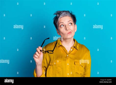 Photo Of Doubtful Attractive Lady Dressed Shirt Glasses Looking Emtpy Space Isolated Blue Color