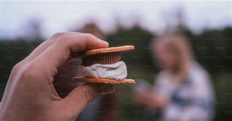 손에 음식 조각을 들고 있는 사람 사진 Unsplash의 스모어 이미지