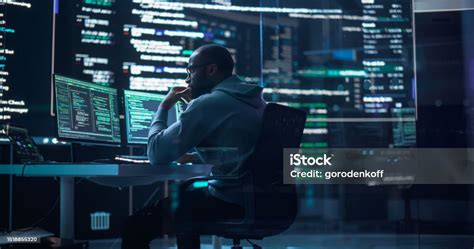 컴퓨터에서 작업하는 흑인 남성의 초상화 모니터링실에서 그를 둘러싼 큰 화면에 나타나는 코드 줄을 입력합니다 Ai 데이터 및