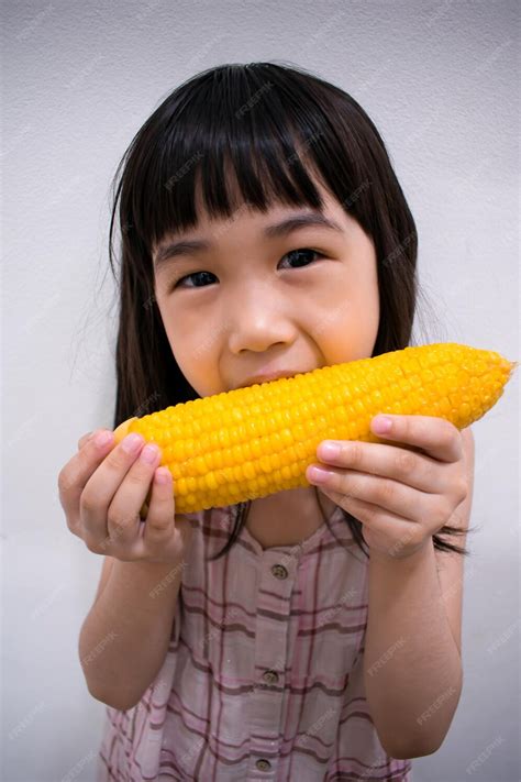 Premium Photo Close Up Portrait Of Smiling Girl Eating Corn