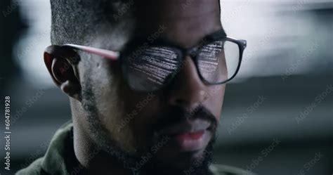 Face, glasses and code with a black man programmer working in a dark office for data processing ...