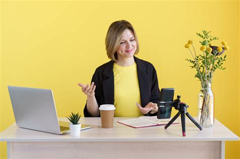 밝은 노란색 배경에 노트북 커피 전화와 꽃 책상에 앉아 젊은 예쁜 여자 비즈니스 우먼 또는 학생 개념 35 39세에 대한 스톡