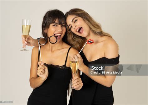 크리스마스 또는 새해 전야 토스트 안경을 축하하는 재미를 가진 두 아름다운 여자 친구 샴페인을 마시는 세련된 섹시한 파티 드레스에서 포즈를 취하는 여성 사람들 우정과 축하