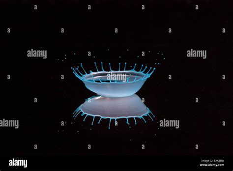Drop Made Of Milk Cream And Colour Hitting A Black Plexiglass Plate