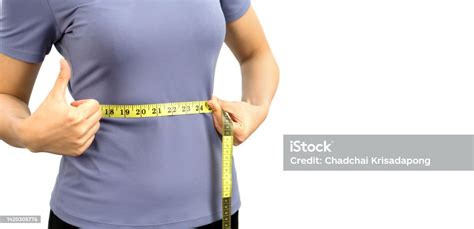 운동복을 입은 클로즈업 여성 손은 허리 주위를 측정하기 위해 줄자를 사용합니다 건강한 영양과 체중 감량 개념 스튜디오 조명이있는 흰색 배경의 초상화 다이어트에 대한 스톡