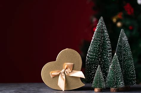 크리스마스 트리와 선물 상자의 아름 다운 크리스마스 휴일 프레임 테이블 표면에 황금 하트 모양의 선물 상자가있는 귀여운 새해 가문비 나무 0명에 대한 스톡 사진 및 기타