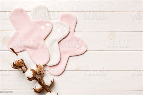 면화 꽃과 화려한 밝은 재사용 가능한 생리대 세트 제로 폐기물 여성 기간 복사 공간이있는 개념 탑 뷰 체내형 생리대에 대한 스톡