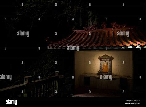 A Dimly Lit Shrine Featuring Traditional Asian Architecture With A Red