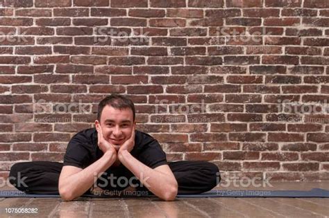 발랄 한 매력적인 젊은 남자 운동 요가 필 라 테 스 휘트니스 교육 벽돌 벽 배경 위에 아사 Baddkha Konasana 스튜디오 촬영 전체 길이 강사에 대한 스톡 사진