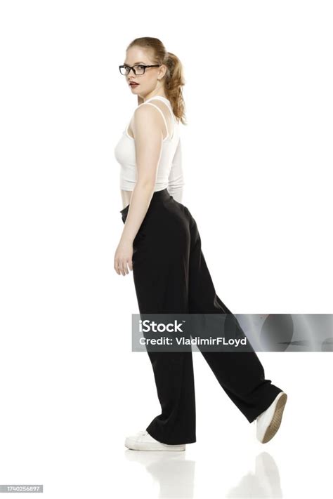 바지를 입고 흰 블라우스를 입은 젊은 금발 여자가 하얀 스튜디오 배경을 걷고 있는 모습 아름다움에 대한 스톡 사진 및 기타 이미지 아름다움 여자 전신 Istock