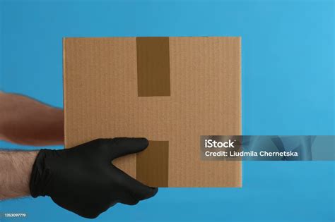 파란색 배경에 골판지 상자를 들고 택배 클로즈업 소포 배달 저장고 제작물에 대한 스톡 사진 및 기타 이미지 저장고 제작물