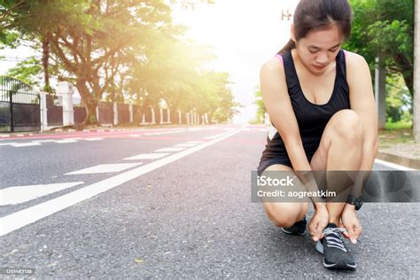 젊은 여성 주자 끈 그녀의 신발 끈을 묶는다 아시아 여성 묶고 그녀의 검은 신발 여자는 워킹 파크에 실행 신발을 착용 건강하고 피트니스 컨셉 복사 공간을 가지고 있습니다