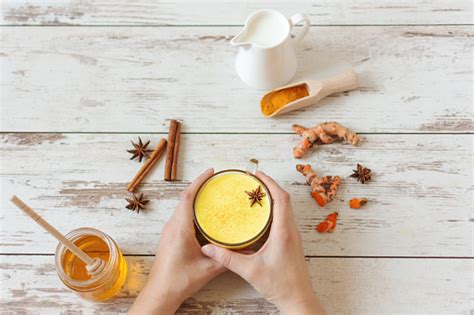 계피와 다른 향기로운 향신료 상단보기와 황금 심황 우유를 들고 여자 손 건강하고 향기로운 해독 음료 한방 의학 항 염증 치료 한 명의 여자만에 대한 스톡 사진 및 기타