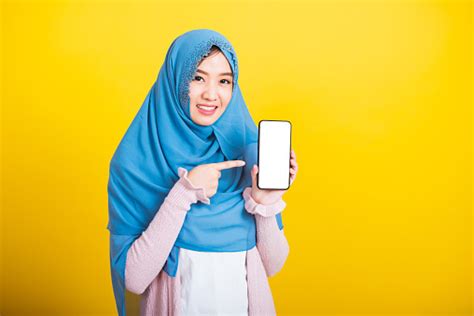 아시아 무슬림 아랍 여자 이슬람 착용 베일 재미있는 미소 그녀는 빈 화면 스마트 휴대 전화를 보여주는 노랑에 대한 스톡 사진 및 기타 이미지 Istock