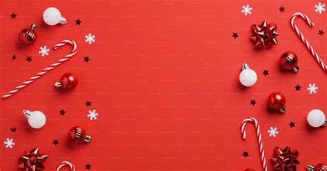 빨간색과 흰색 싸구려 장식 사탕 지팡이 및 색종이가 있는 빨간 크리스마스 배경 크리스마스 엽서 템플릿 배너 모형입니다 사진 Unsplash의 가정 장식 이미지