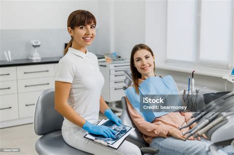 치아 검사 중 환자에게 치료를 설명하는 태블릿 및 엑스레이 사진이있는 친절한 치과 의사 현대 치과 진료소 전문 구강 관리의 개념 스토마토로지 오피스상담 2명에 대한 스톡