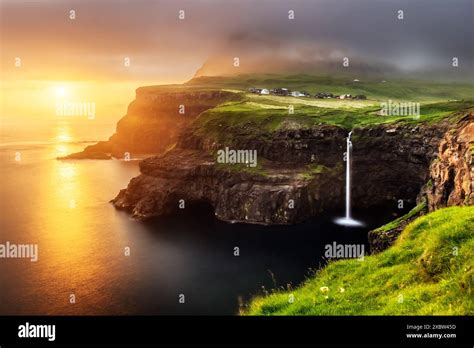 Mulafossur Waterfall On Sunset Time Dramatic Sky With Golden Light