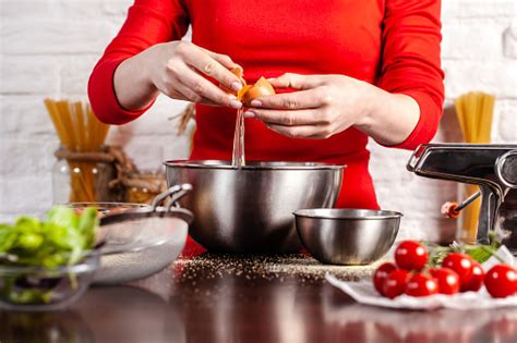 단계별로 이탈리아 파스타 페투치네를 만드는 수동 과정 파스타 메이커와 홈 파스타 밀가루 세몰라 디 그라노 두로 계란 토마토 바질은 나무 테이블에 누워 있습니다 레시피 건강한