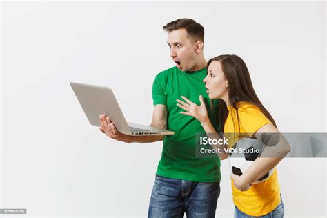 충격된 커플 여자 남자 노란색 녹색 T셔츠 팬 들 축구 축구 공 흰색 배경에 고립 된 Pc 노트북에서 게임을 보고 지원 팀 응원 합니다 스포츠 가족 레저 라이프 스타일