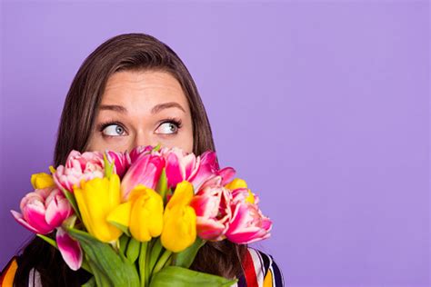고립 된 밝은 보라색 색상 배경에 관심이 빈 공간을 쳐다 선고 튤립 꽃 뒤에 얼굴을 숨기고 소녀의 사진 초상화 갈색 머리에 대한
