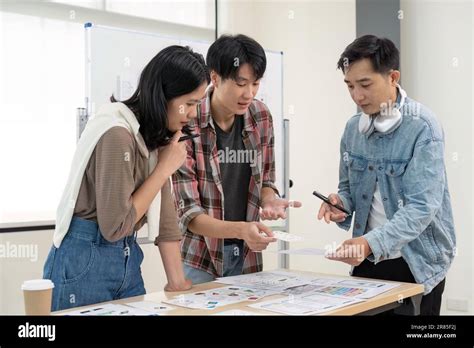 Ux Developer And Ui Designer Brainstorming About App Interface Wireframe Design On Table With