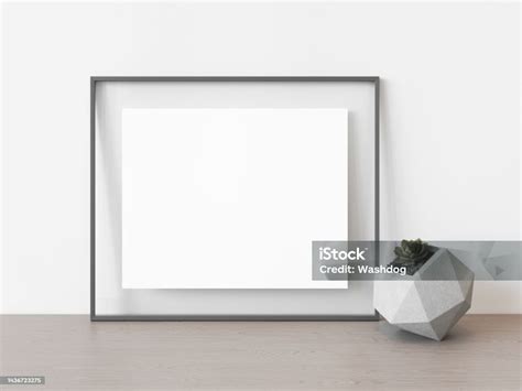 빈 회색 직사각형 수평 프레임은 벽에 밝은 나무 테이블 위에 서 있습니다 포스터 프레임의 모형은 다육 식물 3d 그림으로 홈 인테리어에 닫힙니다 0명에 대한 스톡 사진 및