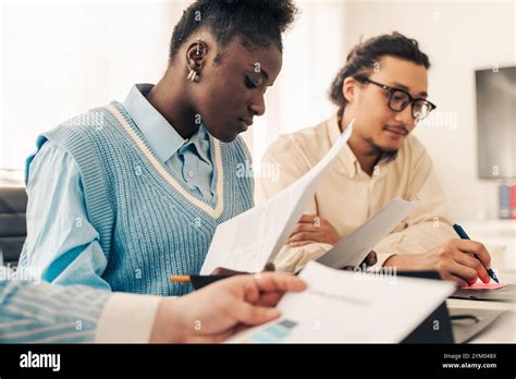 Diverse Young Business Team Reviewing Documents During Collaborative Work Session In Modern