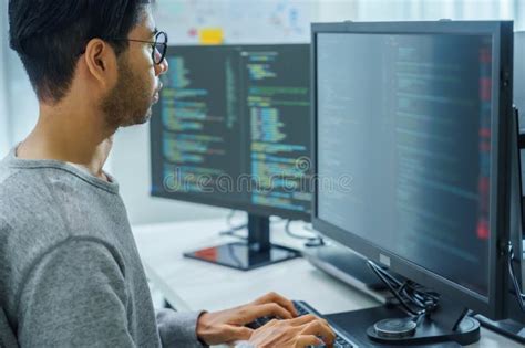 Asian Man Prompt Engineer Develop Coding App With Software Data Sitting In Front Of Computer