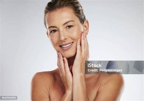 얼굴 웰빙 스킨케어 회색 모형 스튜디오 배경에 대해 피부과 미소를 짓는 성숙한 여성 자연적인 얼굴 피부 관리 및 모형 공간을