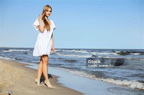 행복한 미소를 짓는 아름다운 여자가 하얀 여름 드레스를 입고 바다 해변을 걷고 있다 18 19세에 대한 스톡 사진 및 기타 이미지 18 19세 건강한 생활방식 걷기