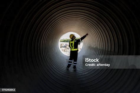 산업 엔지니어들이 원형 수도관 내부를 걷고 있다 엔지니어링 또는 작업자 검사 파이프 원형 물 석유 천연 가스 및 연료 운송 파이프 라인의 건설을 확인합니다 물에 대한 스톡