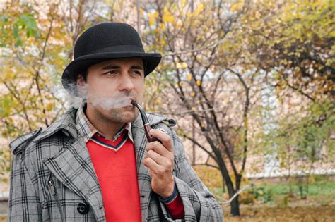 모자를 쓴 중년 남성이 도시 거리를 따라 걷는 동안 파이프를 연기합니다 30 39세에 대한 스톡 사진 및 기타 이미지 30