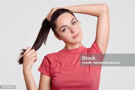 젊은 여성에서 그녀의 검은 머리 포니 테일 하 게 건강 한 피부 메이크업 카메라 흰색 배경 위에 고립 된 캐주얼 옷을 입은에 진정 식 보이는 사람과 아름다움 개념 T 셔츠에