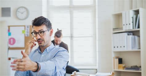 스마트폰을 들고 현대적인 사무실에서 일하는 젊은 사업가가 전화를 걸고 있다 복사 공간 사진 Unsplash의 안경 이미지