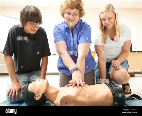 Teacher Demonstrates Cpr Life Saving Techniques For Her Teenage