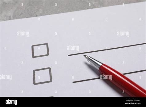 Paper Sheet With Checkboxes And Pen On Light Grey Table Closeup
