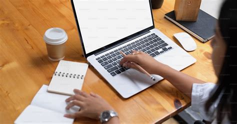 카페의 나무 테이블에서 노트북과 문구류로 작업하는 여성의 자른 사진 클리핑 경로 사진 Unsplash의 랩톱 이미지