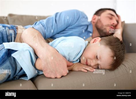 Happy Father And Son Sleeping On Sofa At Home Stock Photo Alamy