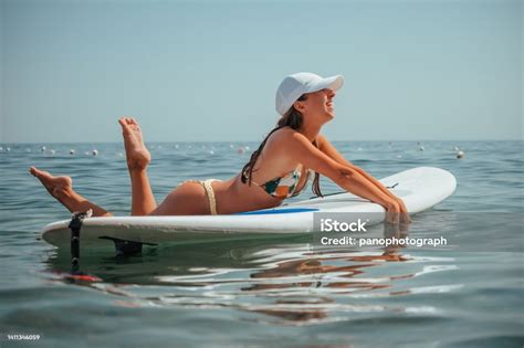 Sup 스탠드 업 패들 보드 맑은 물로 아름다운 잔잔한 바다에서 항해하는 젊은 여성 여름 방학 여행 휴식 자연과 조화를 이루는 활동적이고 건강한 삶의 개념 건강한 생활방식에