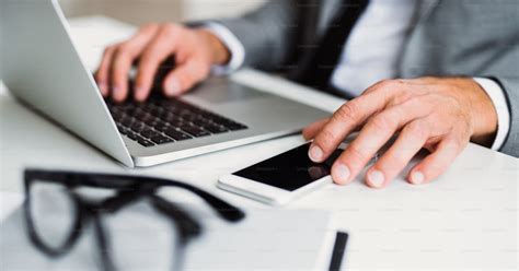 스마트폰 안경 노트북을 든 사업가가 사무실 테이블에 앉아 일하고 있다 복사 공간 사진 Unsplash의 사업 이미지