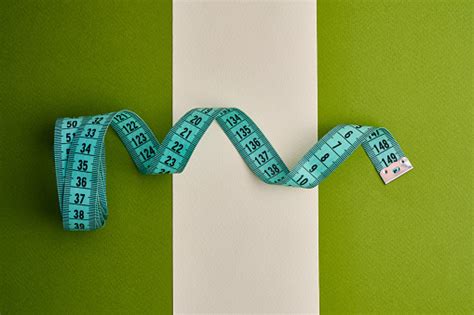 밝은 배경에 녹색 측정 테이프입니다 길이와 부피를 측정하기 위한 도구입니다 의류 산업 또는 인체의 부피를 측정하기 위한 테이프 리본에 대한 스톡 사진 및 기타 이미지