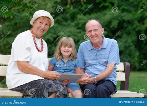 Grandmother And Grandfather With Granddaughter Showing Hands In Clay