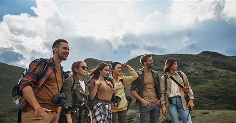 모험을 떠날 준비가 되었습니다 활발하고 열정적인 젊은이들이 큰 배낭을 메고 서서 산에 있는 동안 먼 곳을 주의 깊게 바라보고 있습니다 사진 Unsplash의 하이킹 이미지