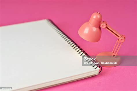 분홍색 배경에 메모장 노트북 근처의 장난감 테이블 램프 램프 근처의 텍스트를 위한 공간과 여유 공간을 복사합니다 루치 공간과 창조적 인 아이디어의 개념 0명에 대한 스톡