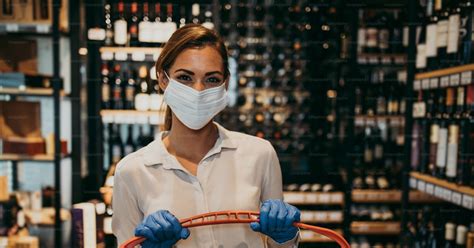 얼굴 보호 마스크와 장갑을 낀 아름다운 젊고 우아한 여성이 현대적인 슈퍼마켓이나 식료품점에서 건강 식품과 음료를 구입합니다 전염병 또는 전염병 생활 방식 및 소비주의 개념